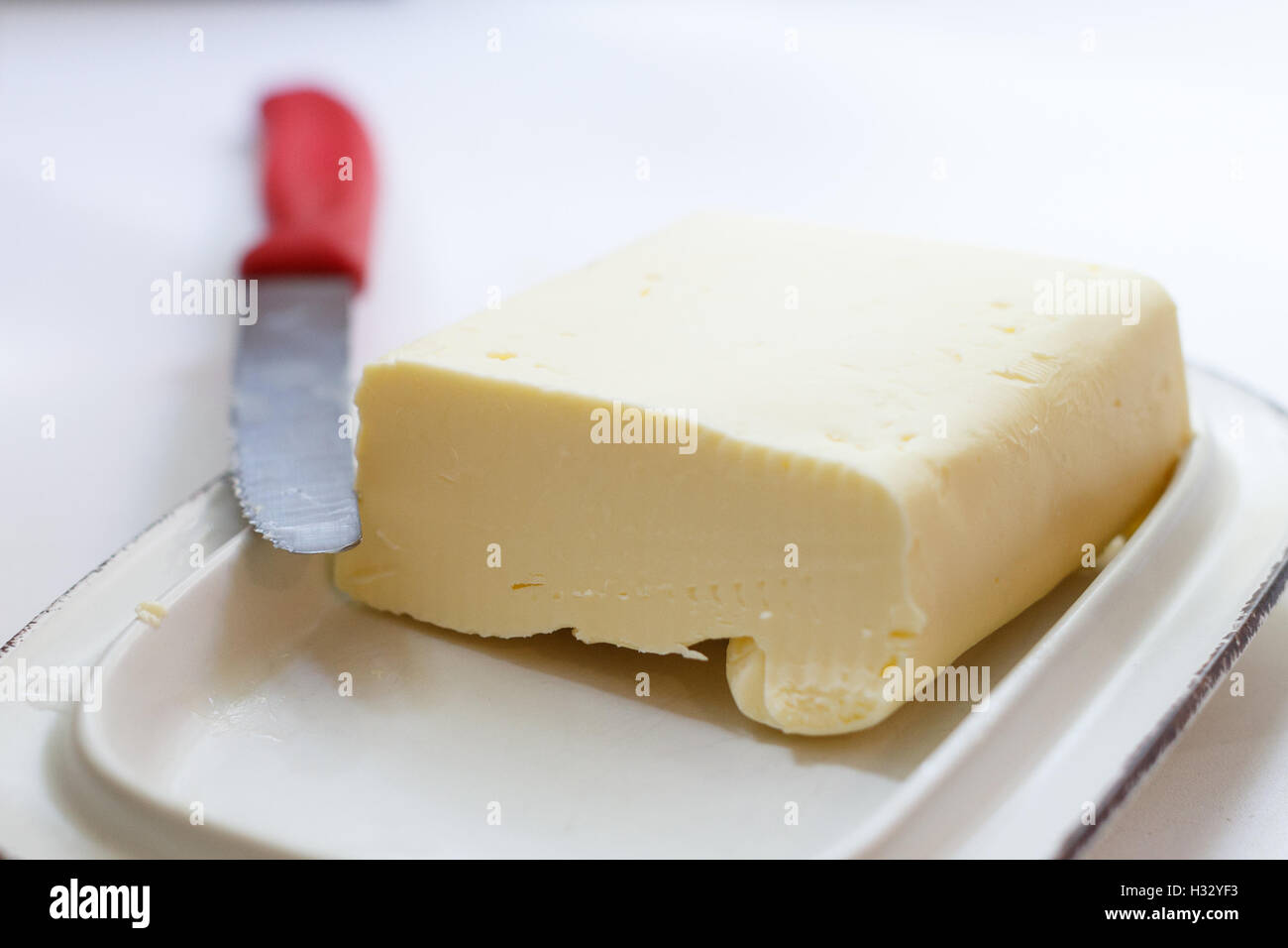 Pat of fresh farm butter on a butter dish with a knife Stock Photo - Alamy