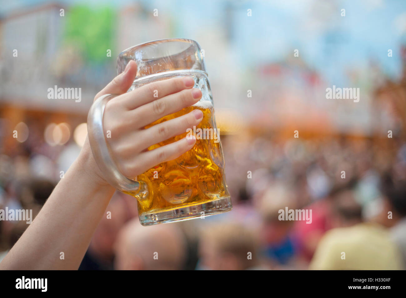 Raised beer mug toasting at Oktoberfest Stock Photo - Alamy