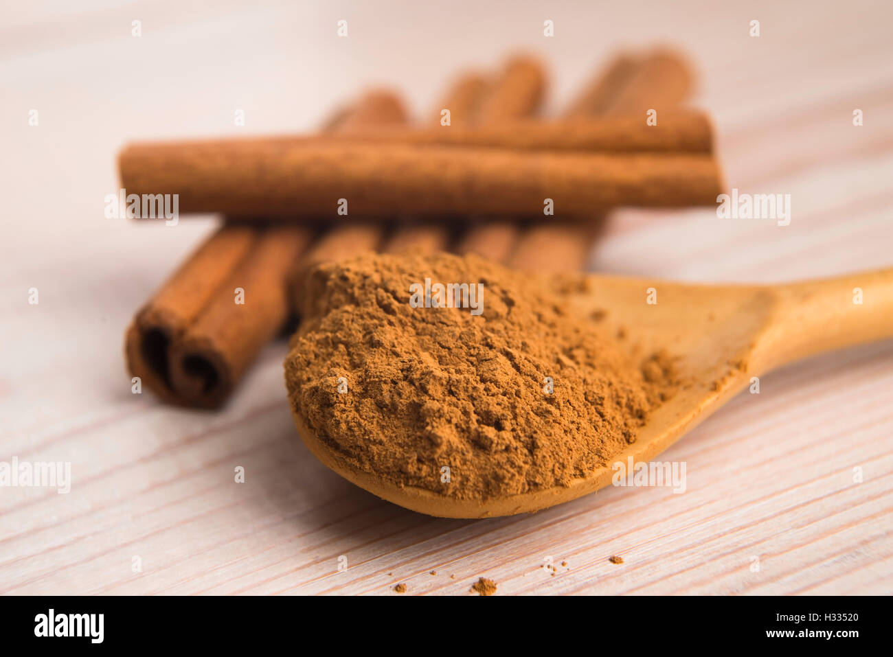 Cinnamon, whole sticks behind wooden spoon with a heap of powder Stock ...
