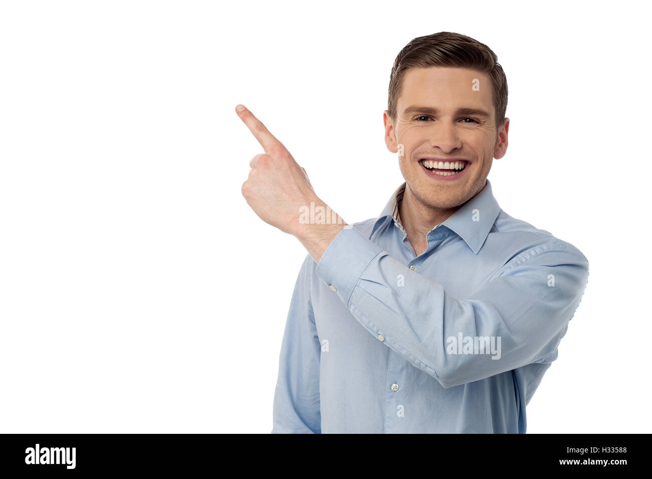 Happy young man pointing at something Stock Photo - Alamy