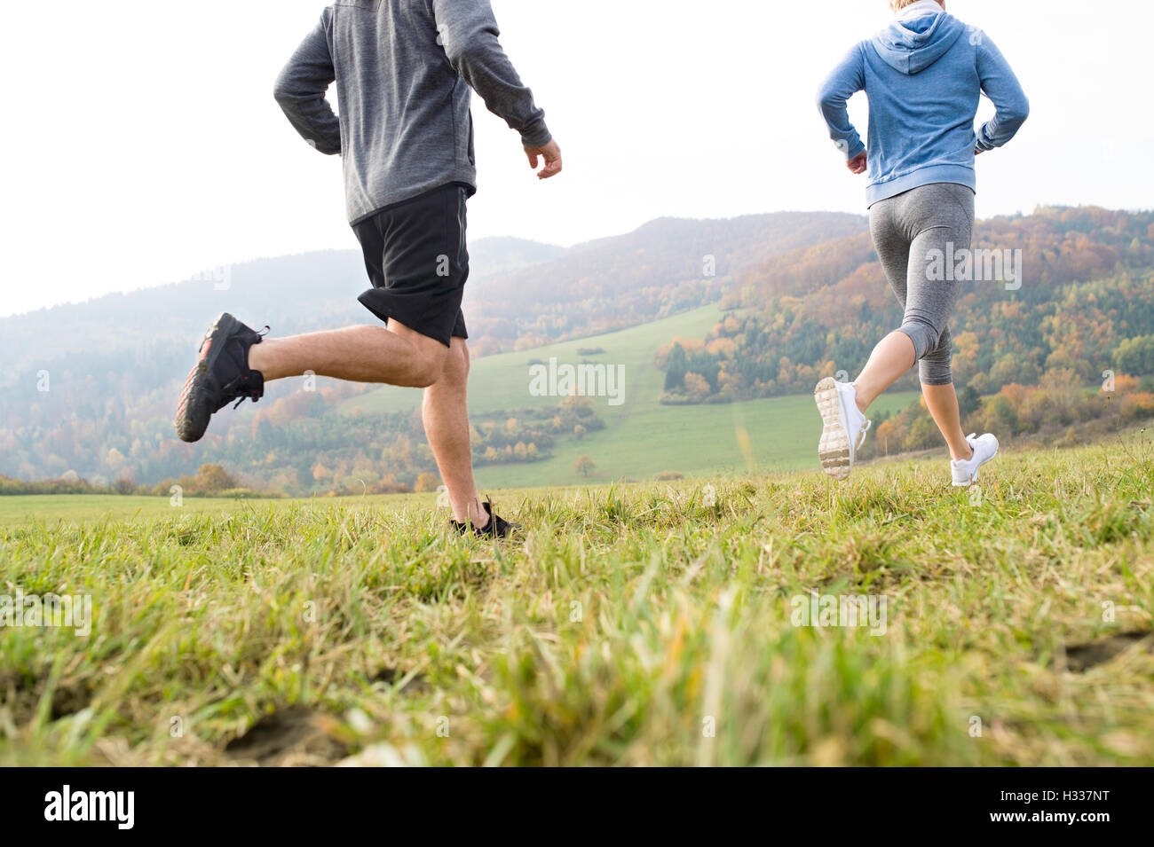 Legs of unrecognizable couple running in autumn nature Stock Photo - Alamy