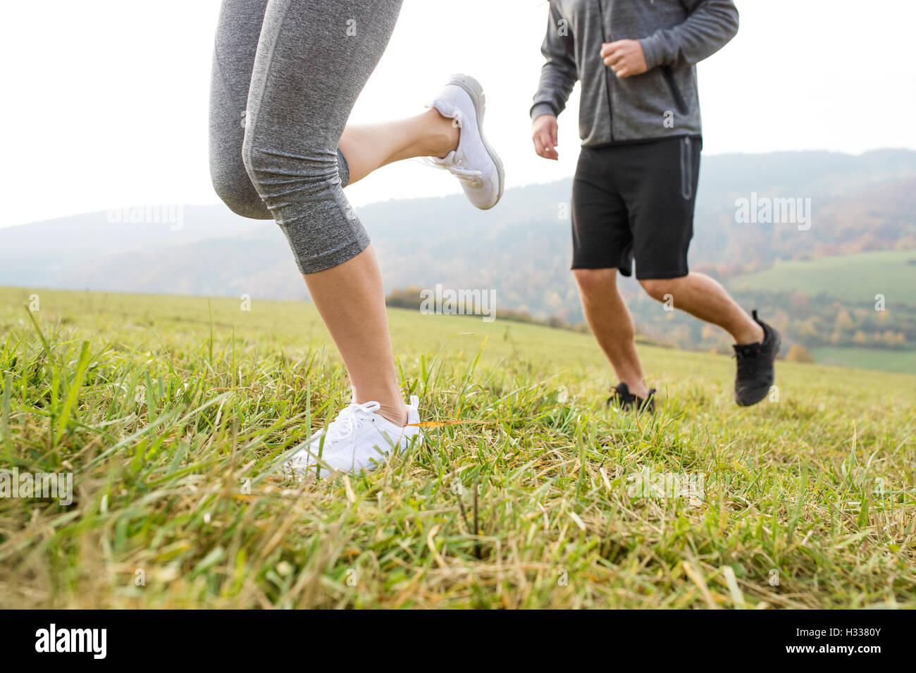 Legs of unrecognizable couple running in autumn nature Stock Photo - Alamy