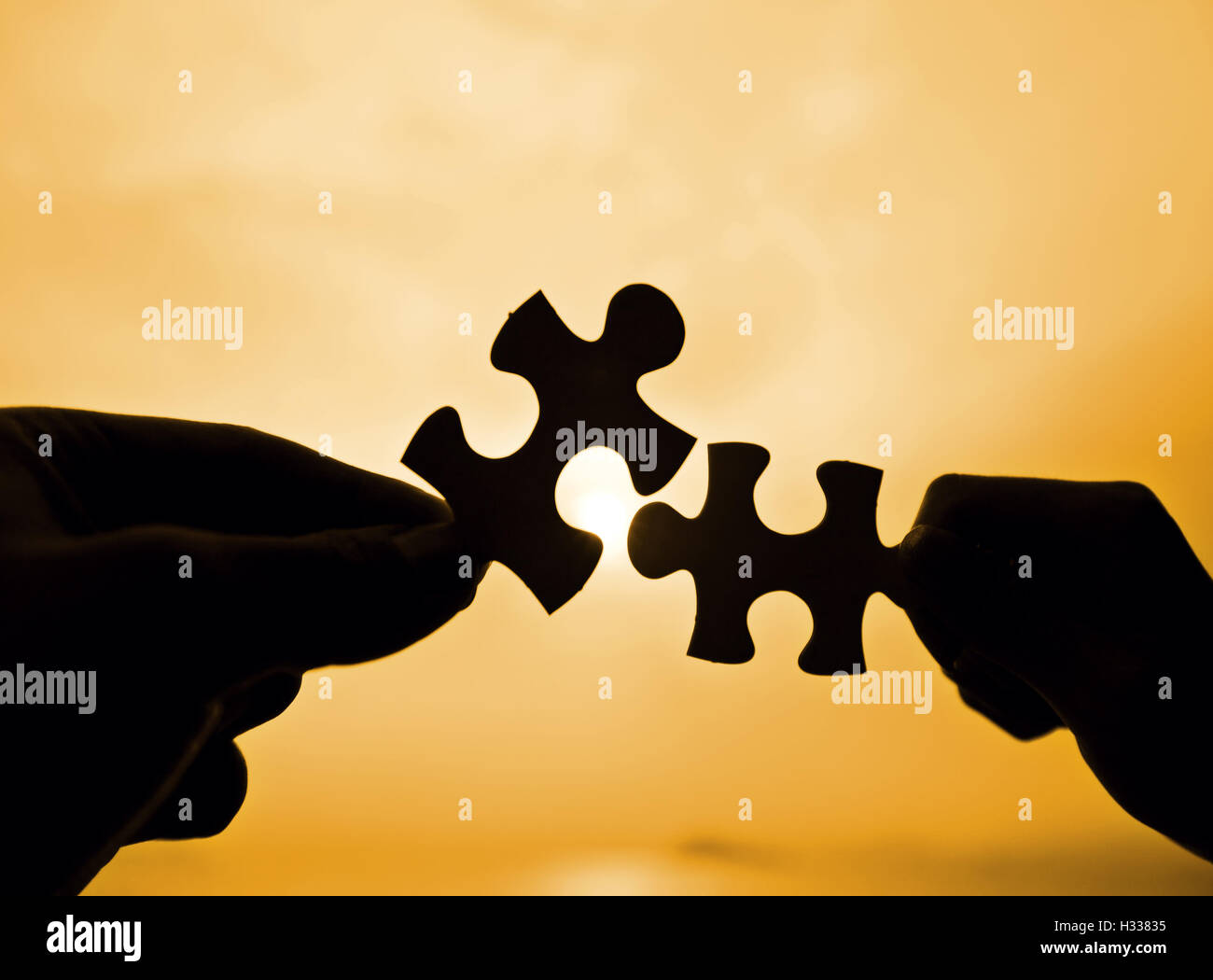Puzzle connection from two hand Stock Photo - Alamy