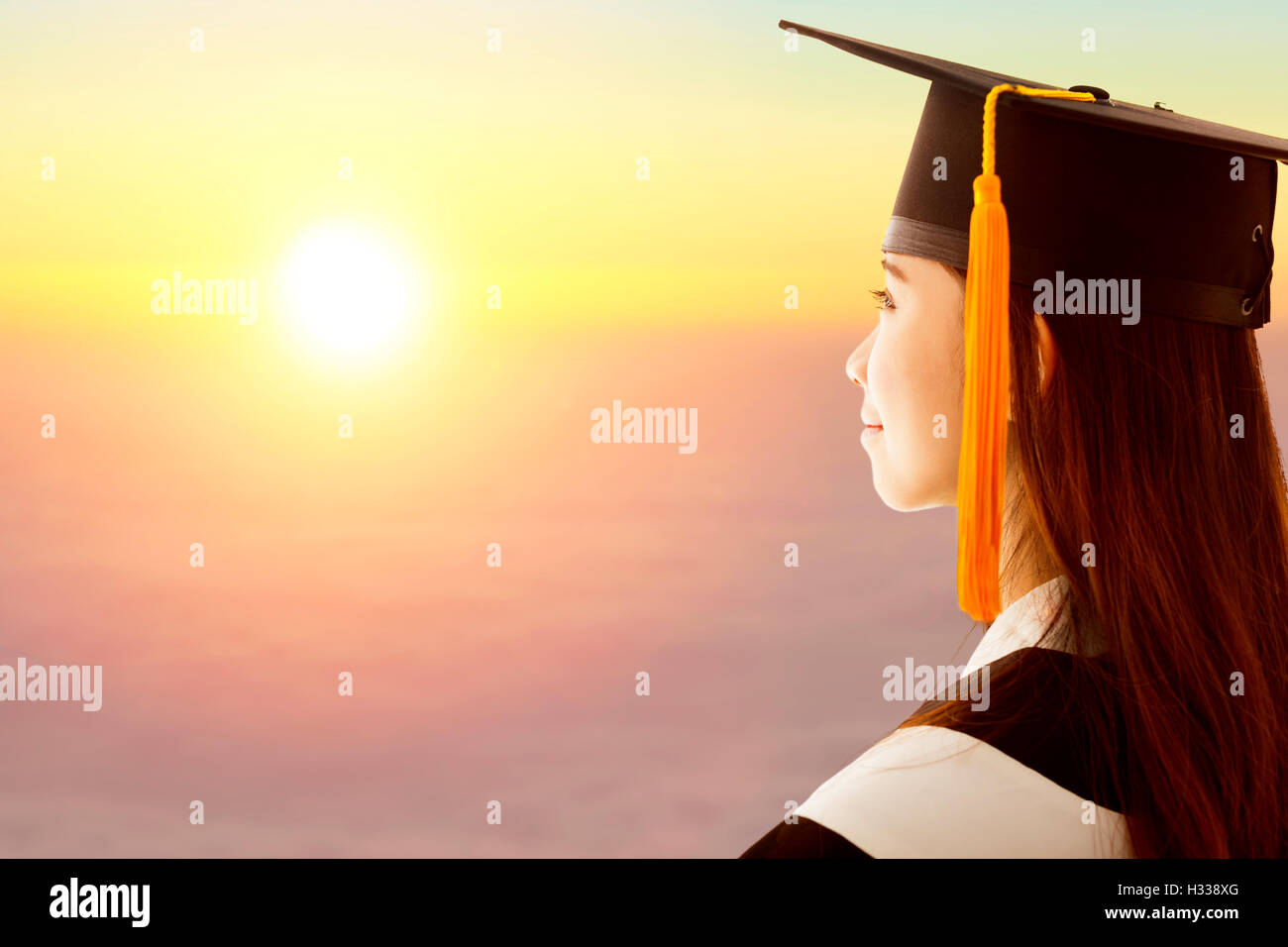 female graduation is thinking future with sunset background Stock Photo ...