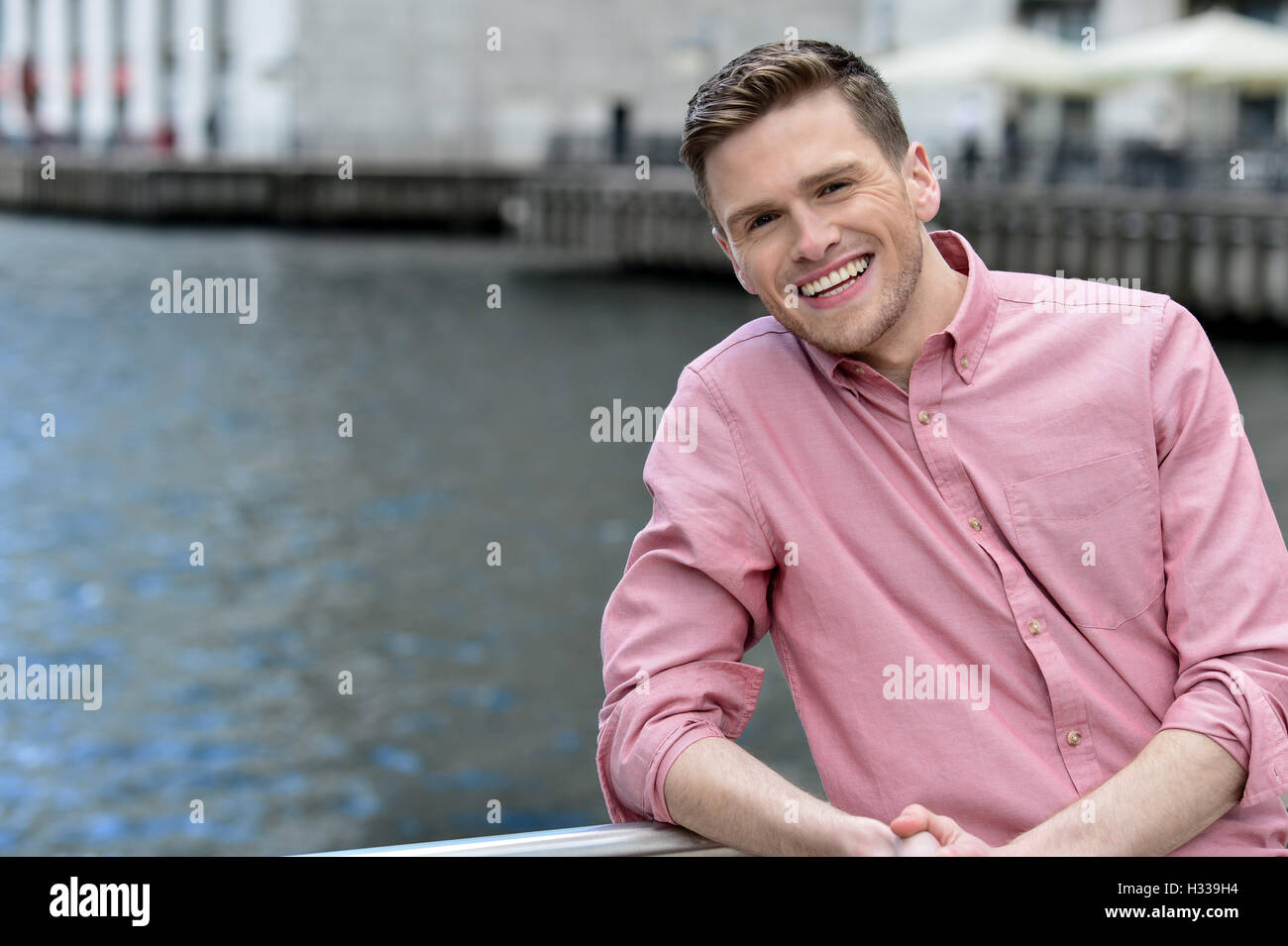 Handsome young man posing near railing Stock Photo - Alamy