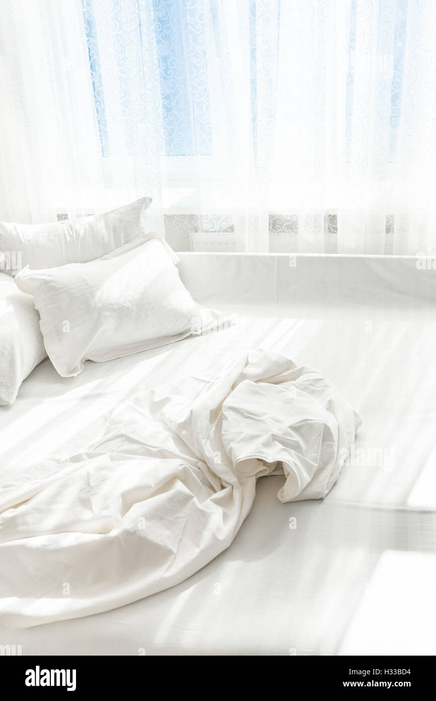 unmade bed against window Stock Photo - Alamy