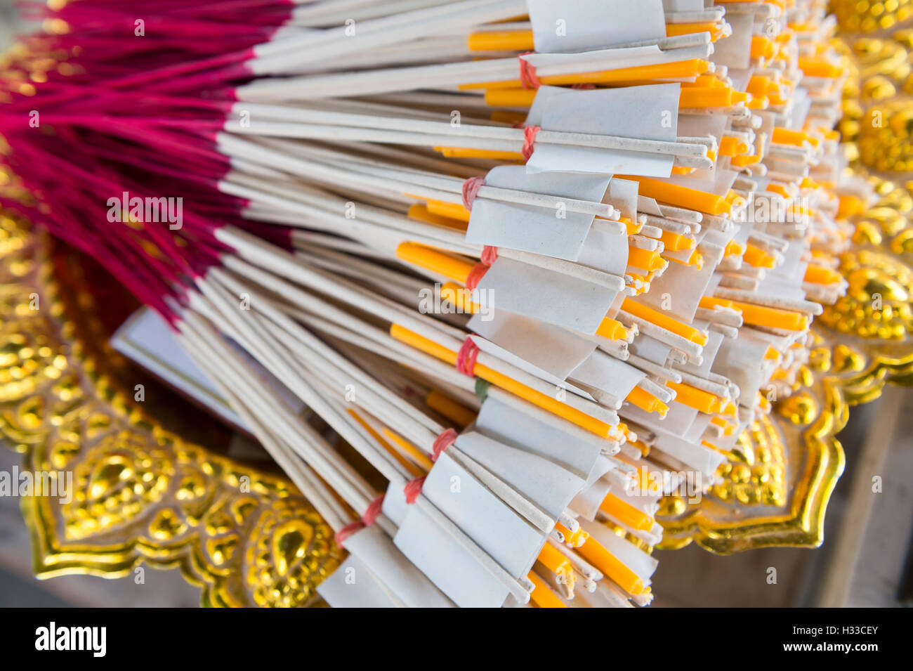 Red sticks of incense on decorative gold tray at a Buddhist shrine in ...