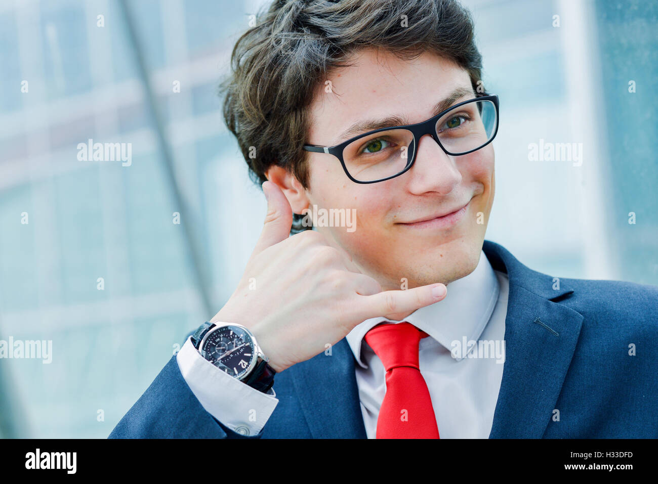 Dynamic junior executive gesturing to call Stock Photo - Alamy