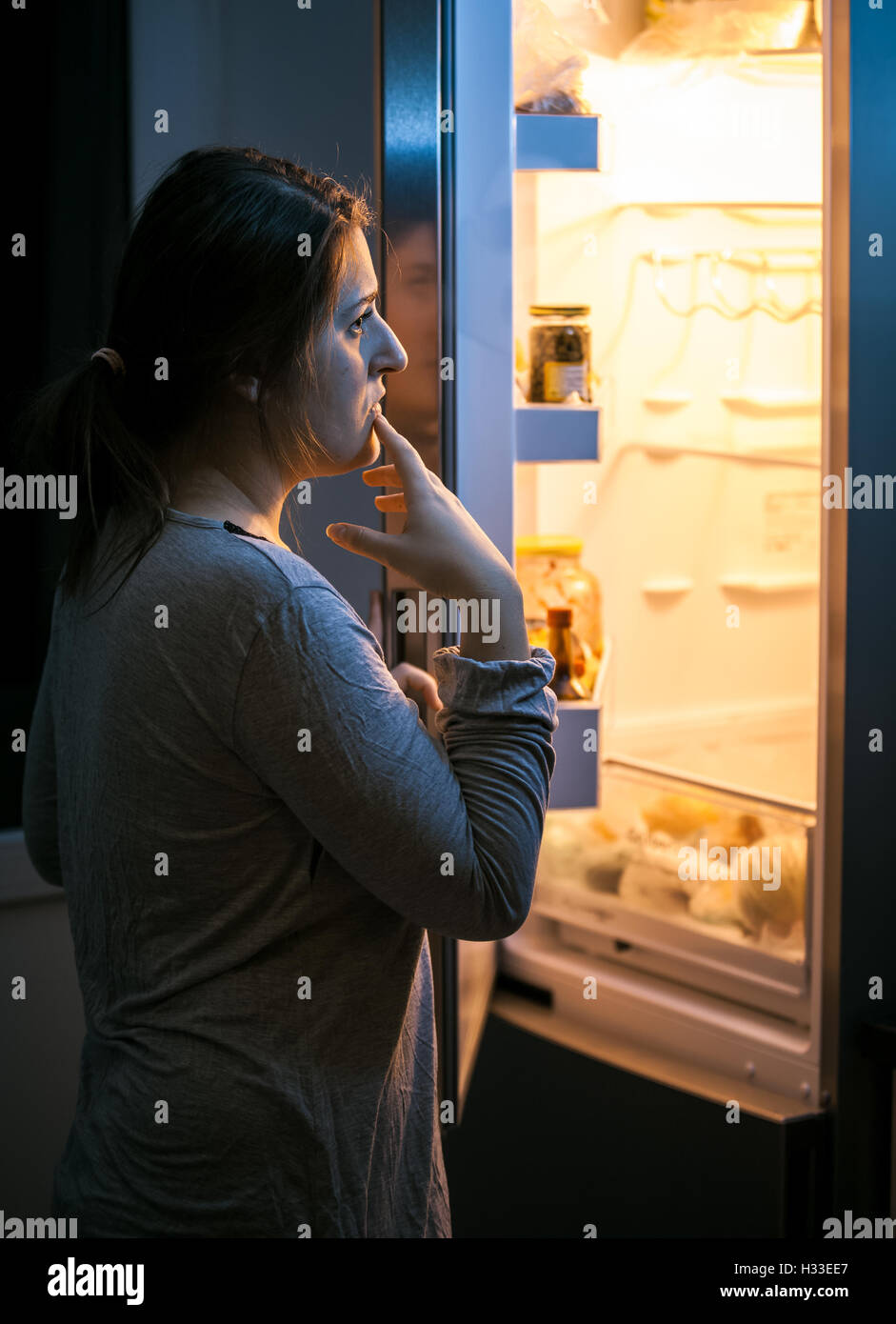 woman looking in the refrigerator at late evening Stock Photo - Alamy