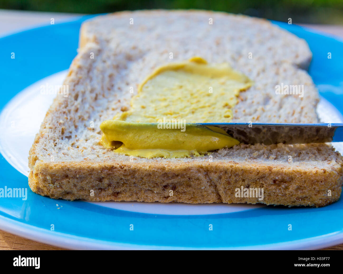knife spreading mustard on bread Stock Photo - Alamy