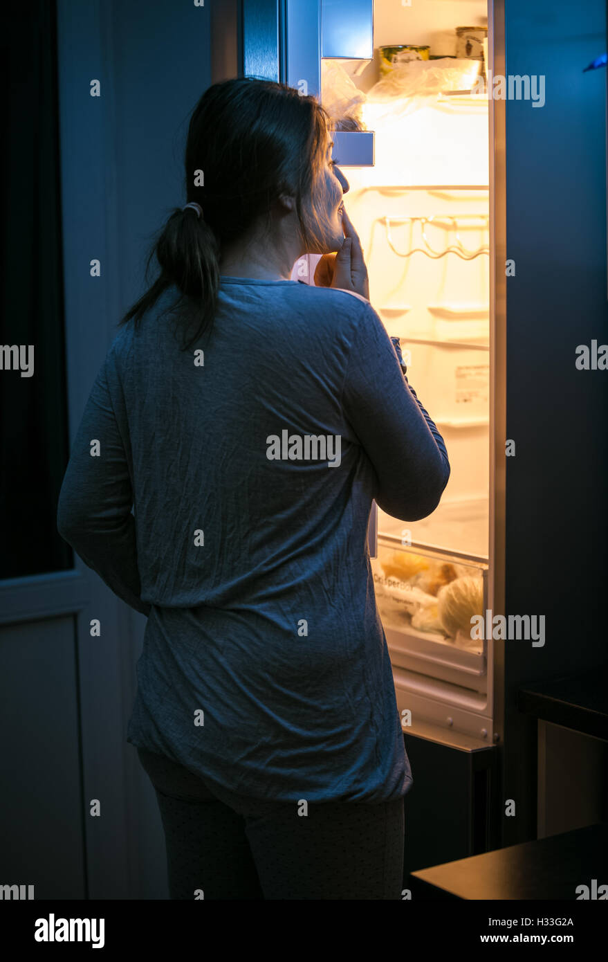 young woman looking inside the fridge at late night Stock Photo - Alamy