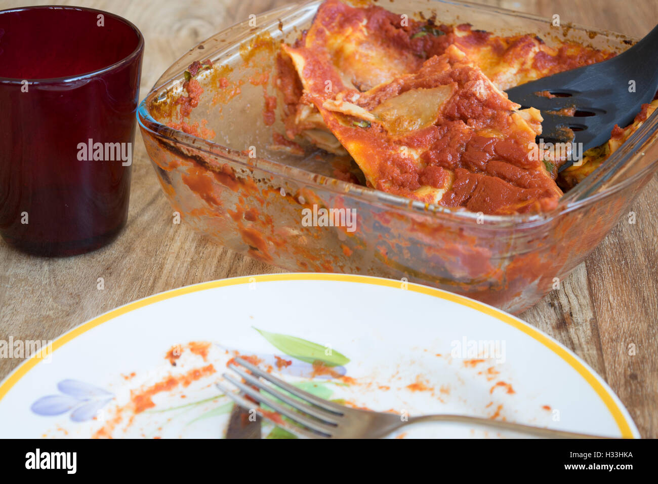 eating lasagne with leftovers and used dishes Stock Photo - Alamy