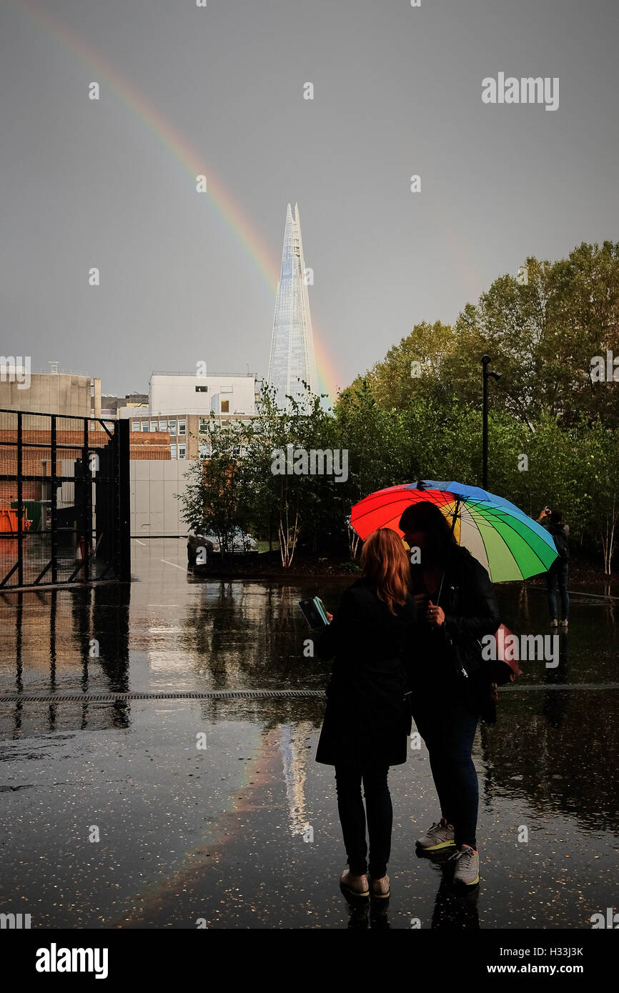 Rainbow over The Shard in London with two people with a multicolored ...
