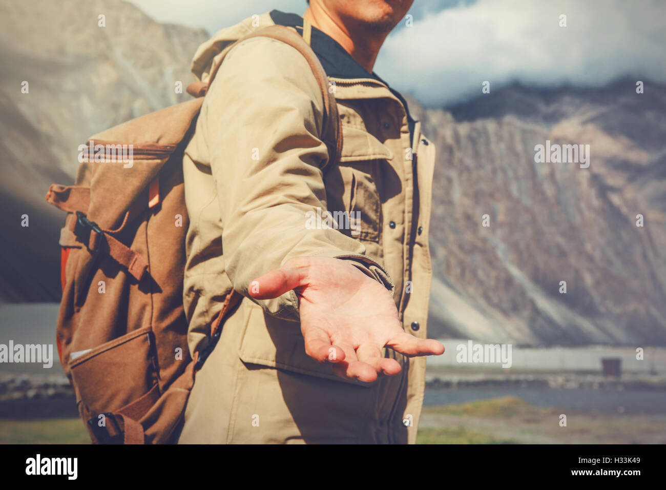 Young travel man lending a helping hand in outdoor mountain scenery ...