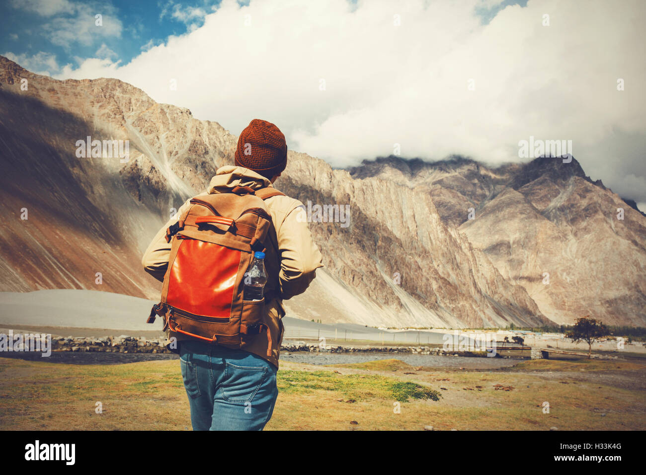 Back of young travel backpacker walking towards the highland mountain ...
