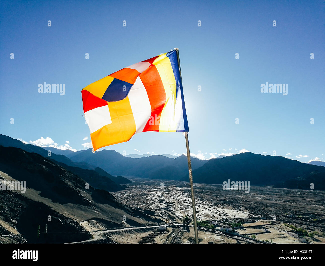 One single Buddhist prayer flag in six colors fluttering in mountain ...