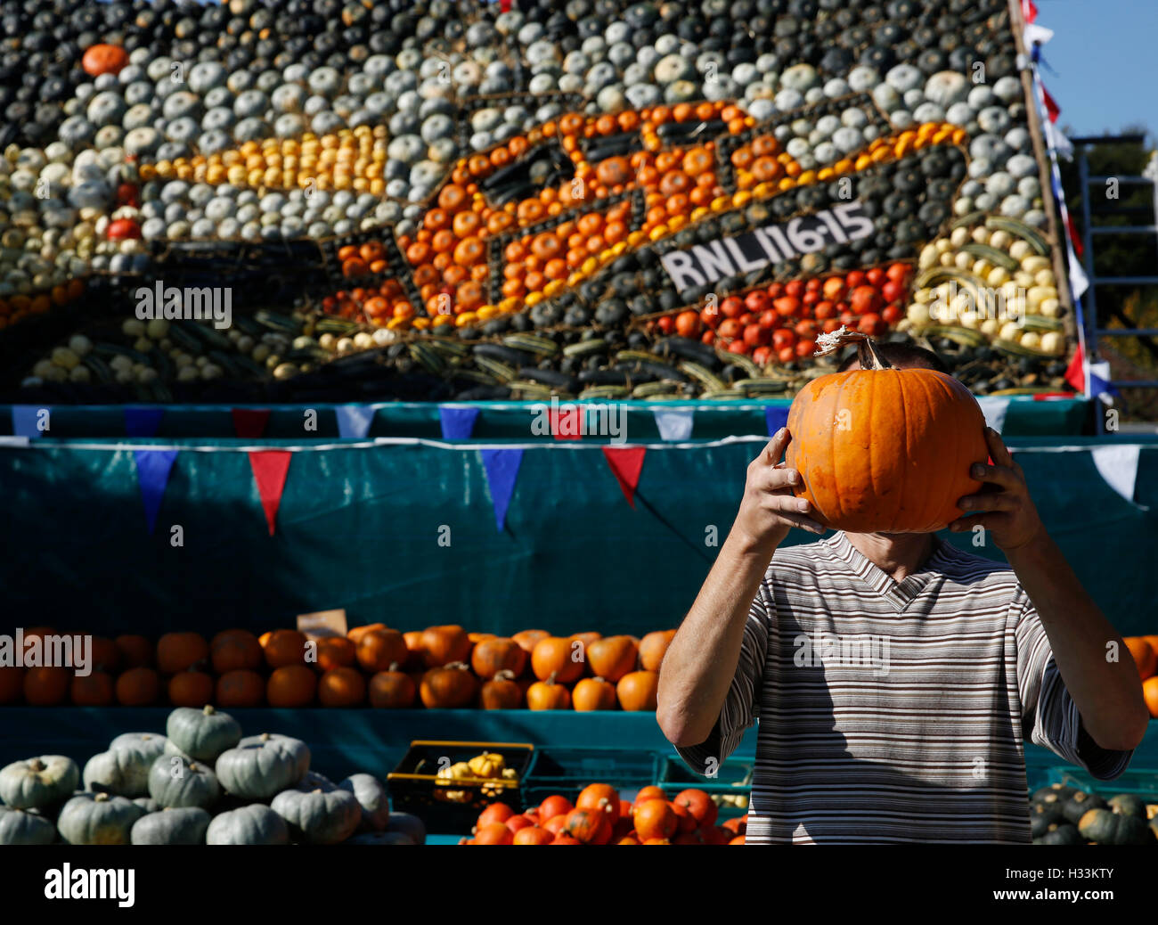 Man holds pumpkin with RNLI Lifeboat picture made from squashes, gourds ...
