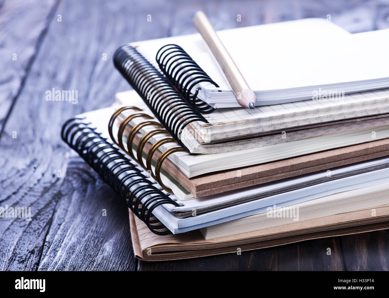 Stack of spiral notebooks on a table Stock Photo - Alamy