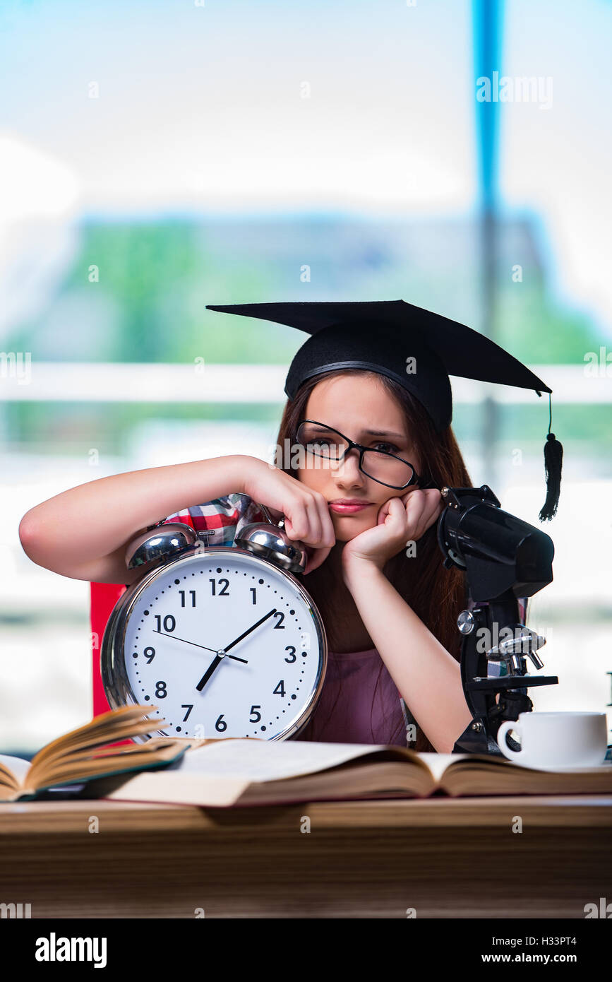 Young girl preparing for exams with large clock Stock Photo - Alamy