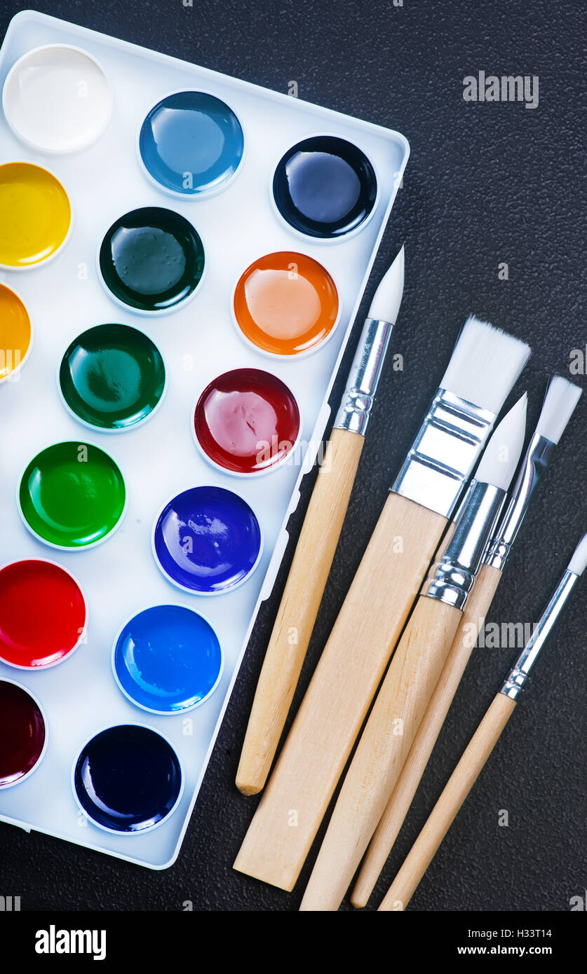 paint and brushes on the black table Stock Photo - Alamy
