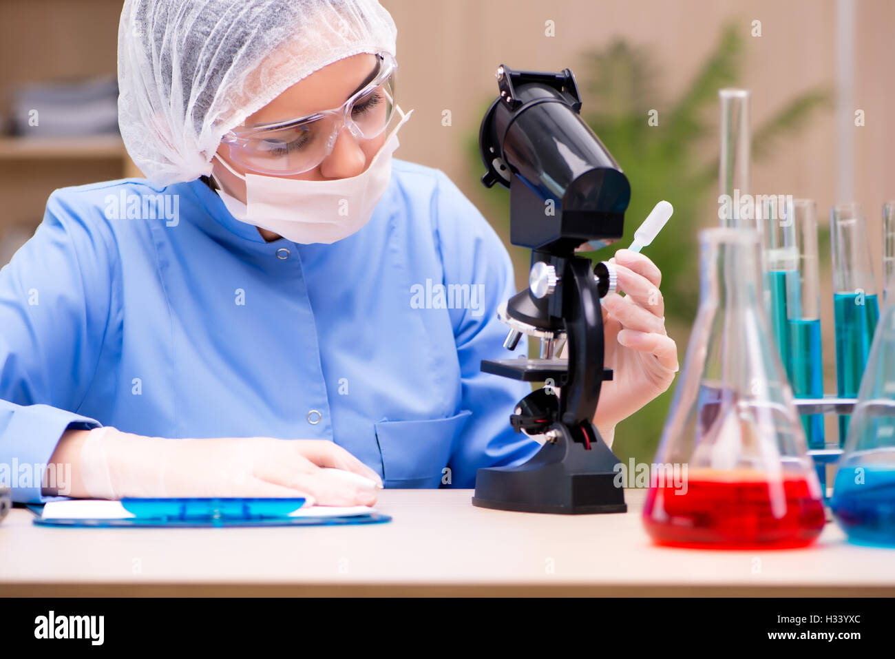 Lab chemist working with microscope and tubes Stock Photo - Alamy