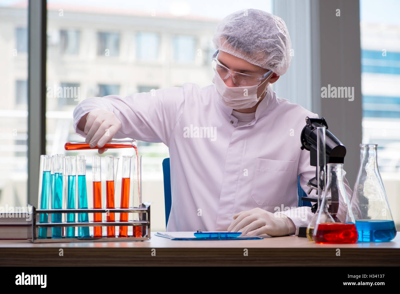 Young chemist working in the lab Stock Photo - Alamy