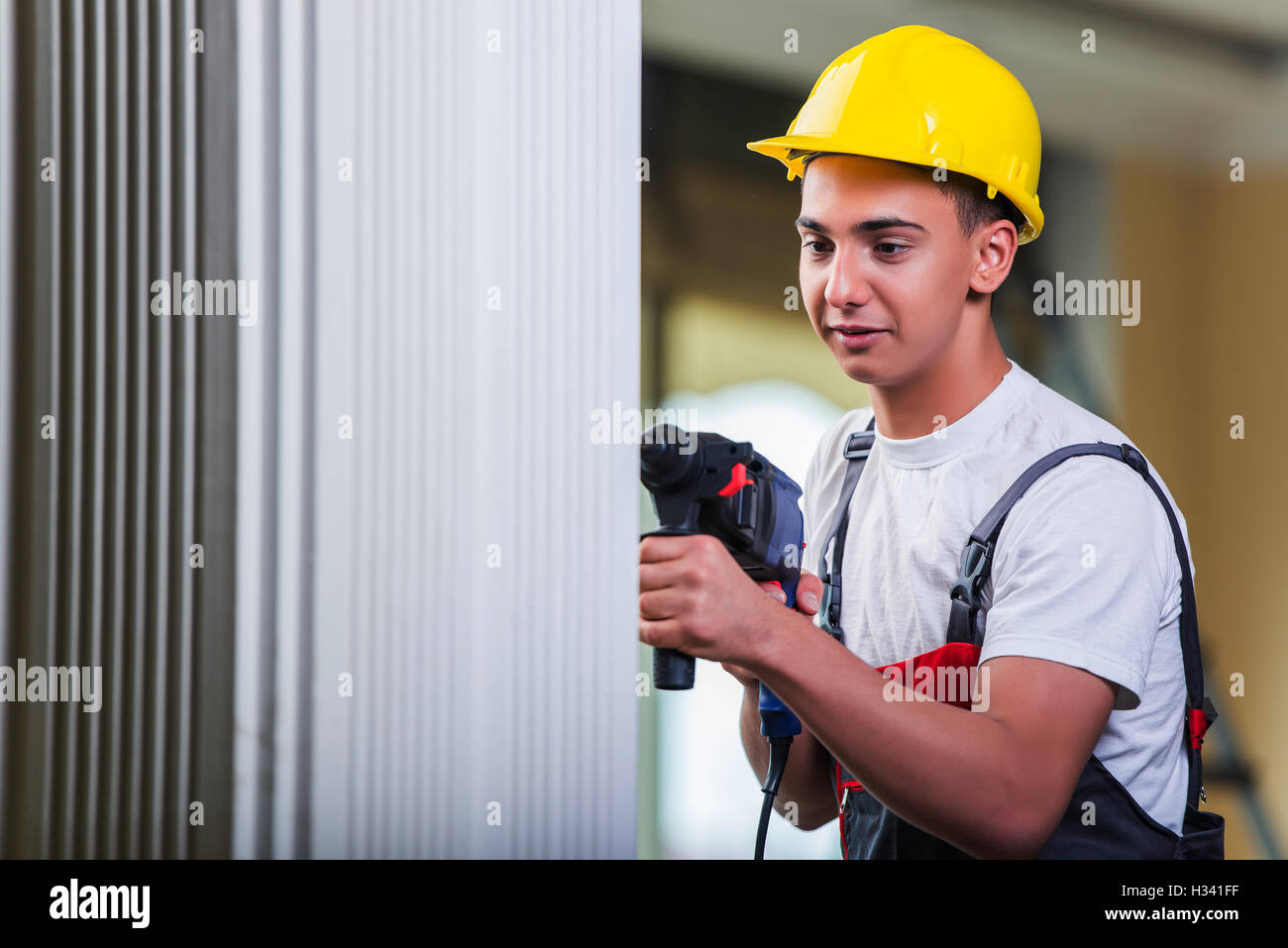 Man drilling the wall with drill perforator Stock Photo - Alamy