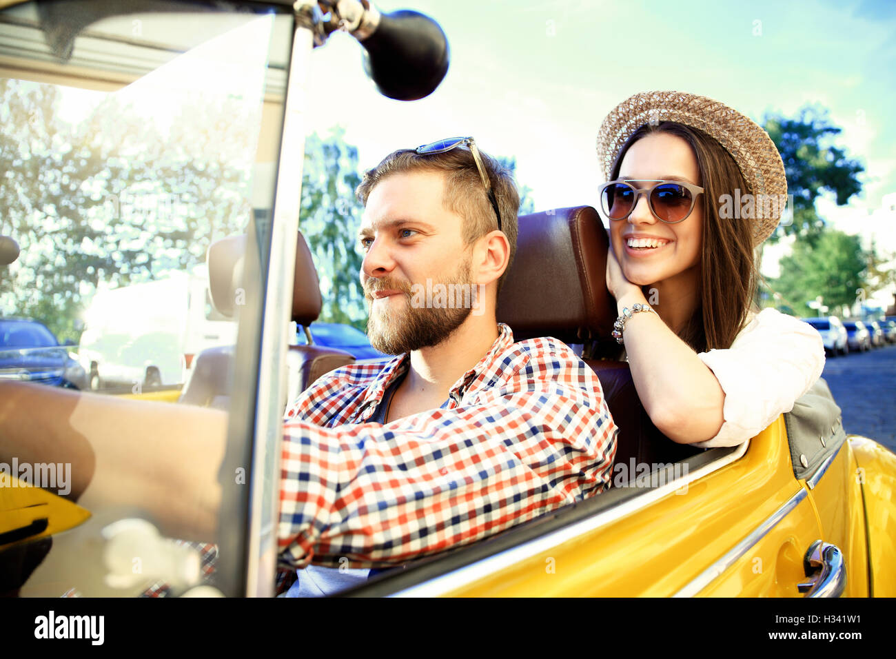 Couple in convertible. Beautiful young couple enjoying road trip in ...