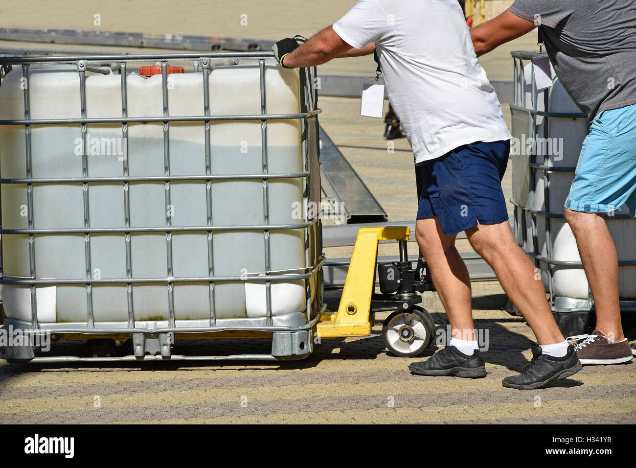 Men are moving a large water container with a hydraulic forklift Stock ...