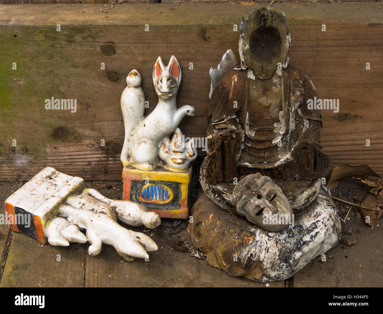 Faceless buddha and shinto kitsune foxes, old and broken sacred statues ...