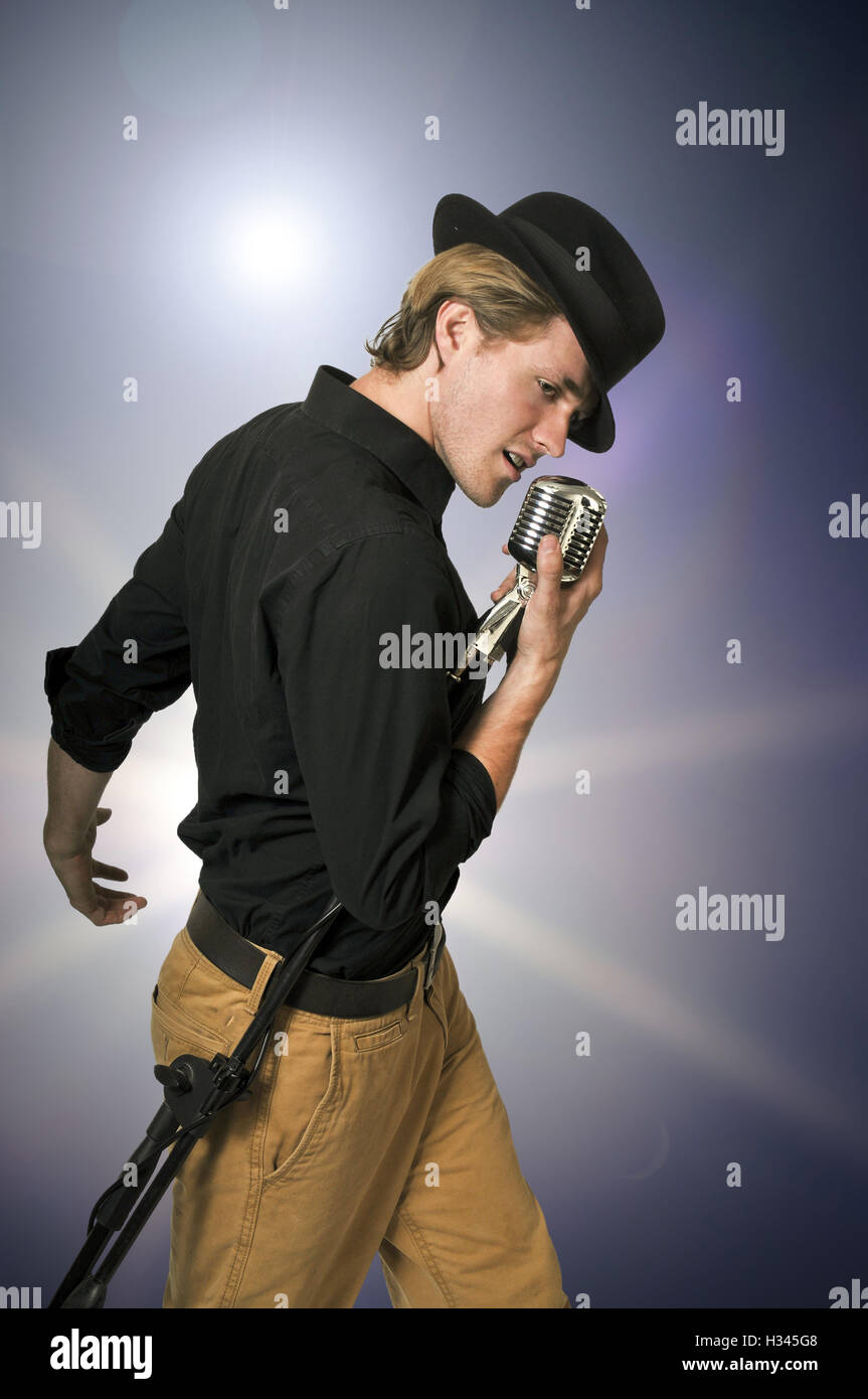 Handsome man singing with a vintage microphone Stock Photo - Alamy