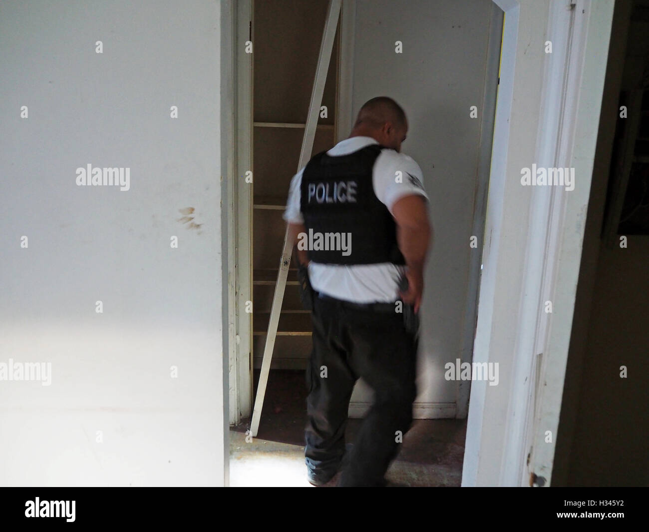 Police officer searches a house in Detroit, Michigan, USA Stock Photo ...