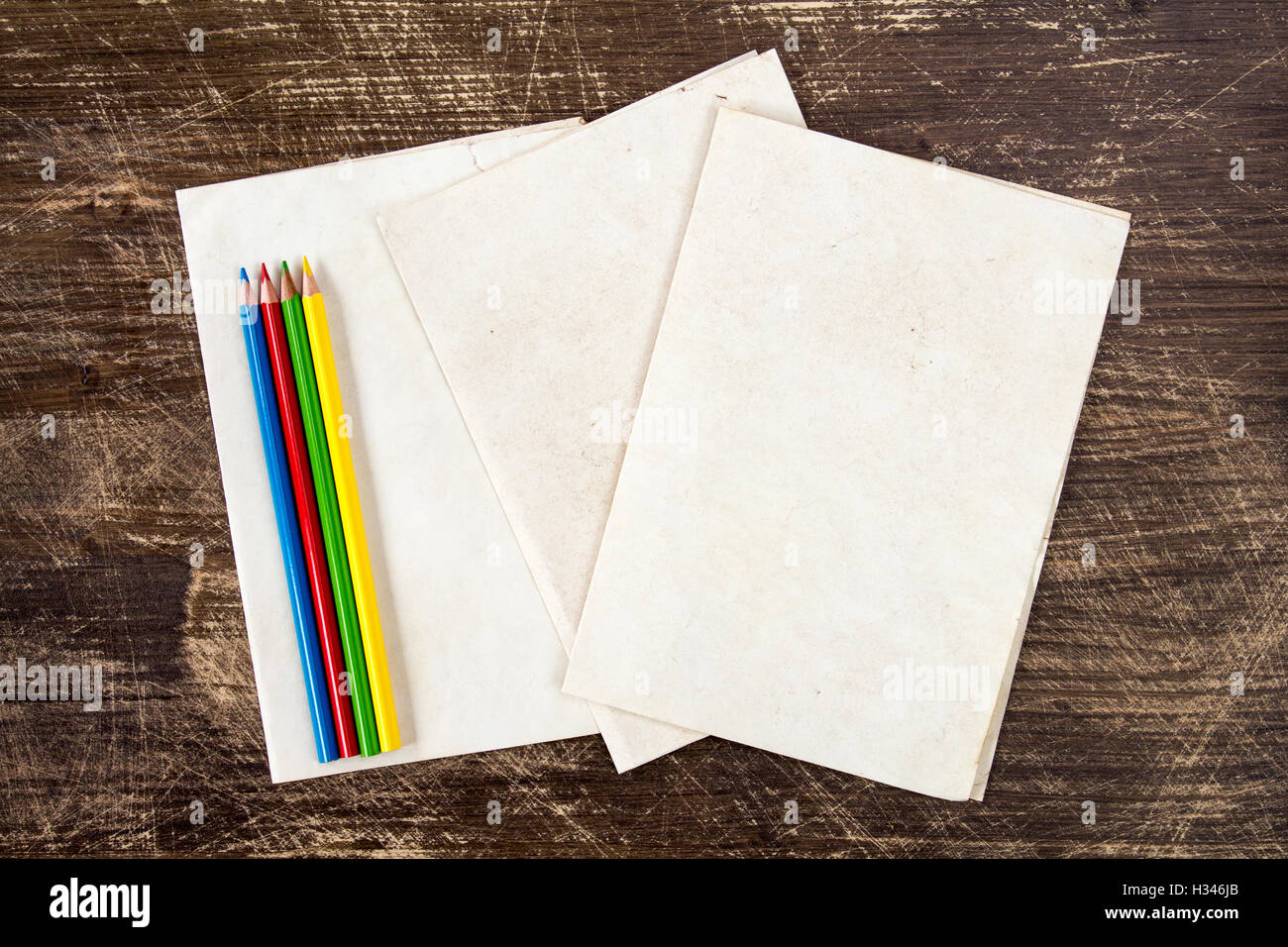 Four color pencils with copy-space on paper background Stock Photo - Alamy