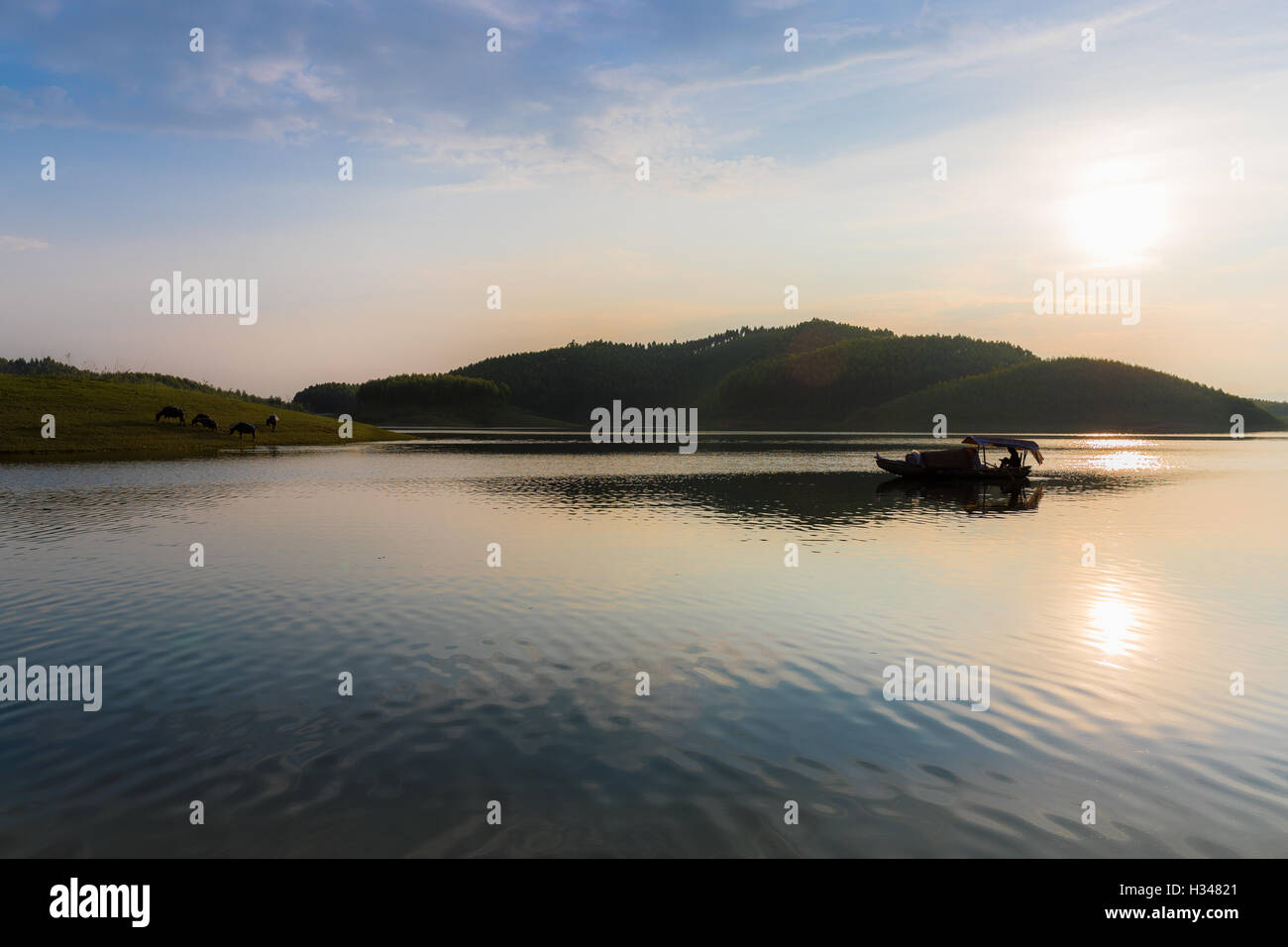 Small wooden boat in sunset Stock Photo - Alamy