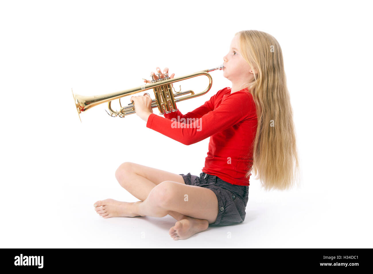 young girl in red playing trumpet Stock Photo - Alamy