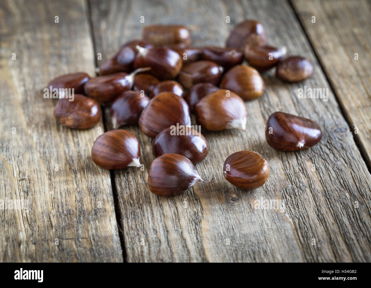 Raw chestnuts on rustic wooden board Stock Photo - Alamy
