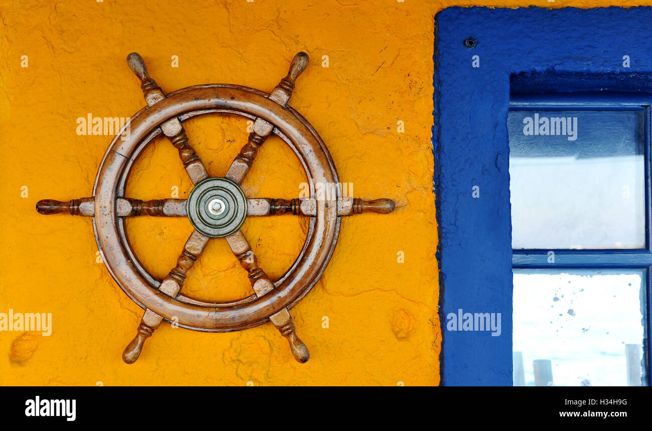 Boat wheel on wall Stock Photo - Alamy