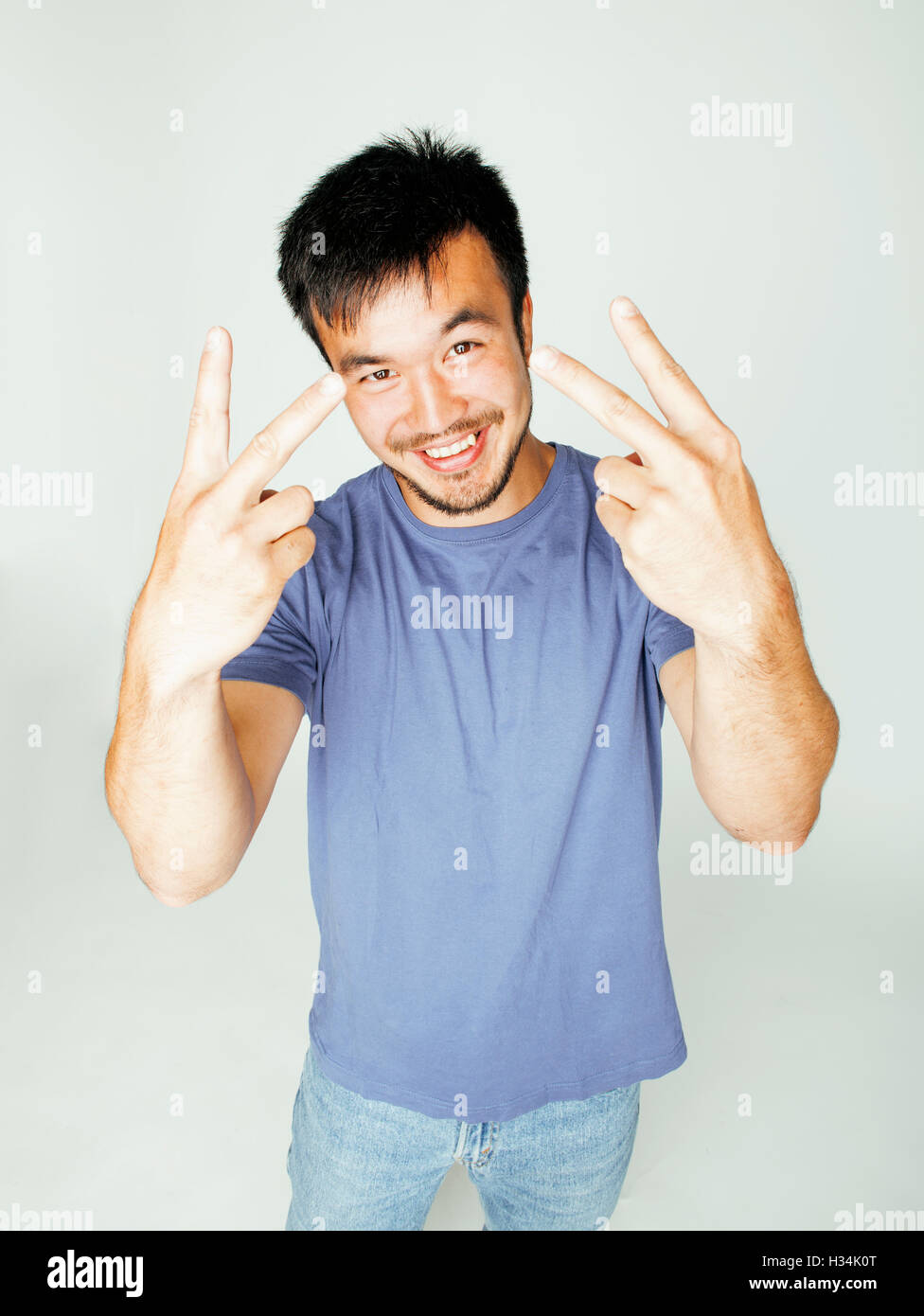 young cute asian man on white background gesturing emotional, pointing ...