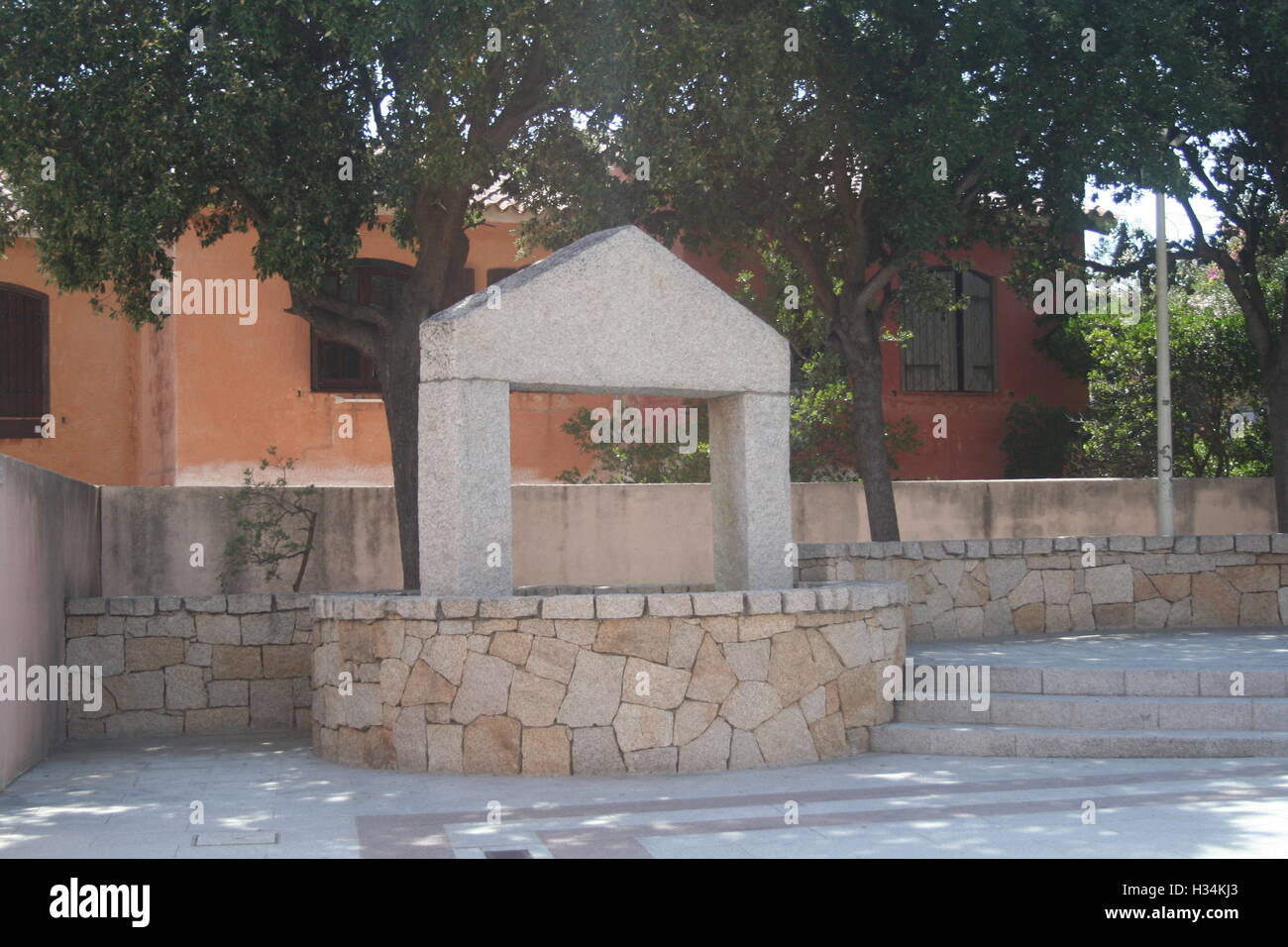 A stone well, beside some steps, in a town in Sardinia, Italy Stock ...