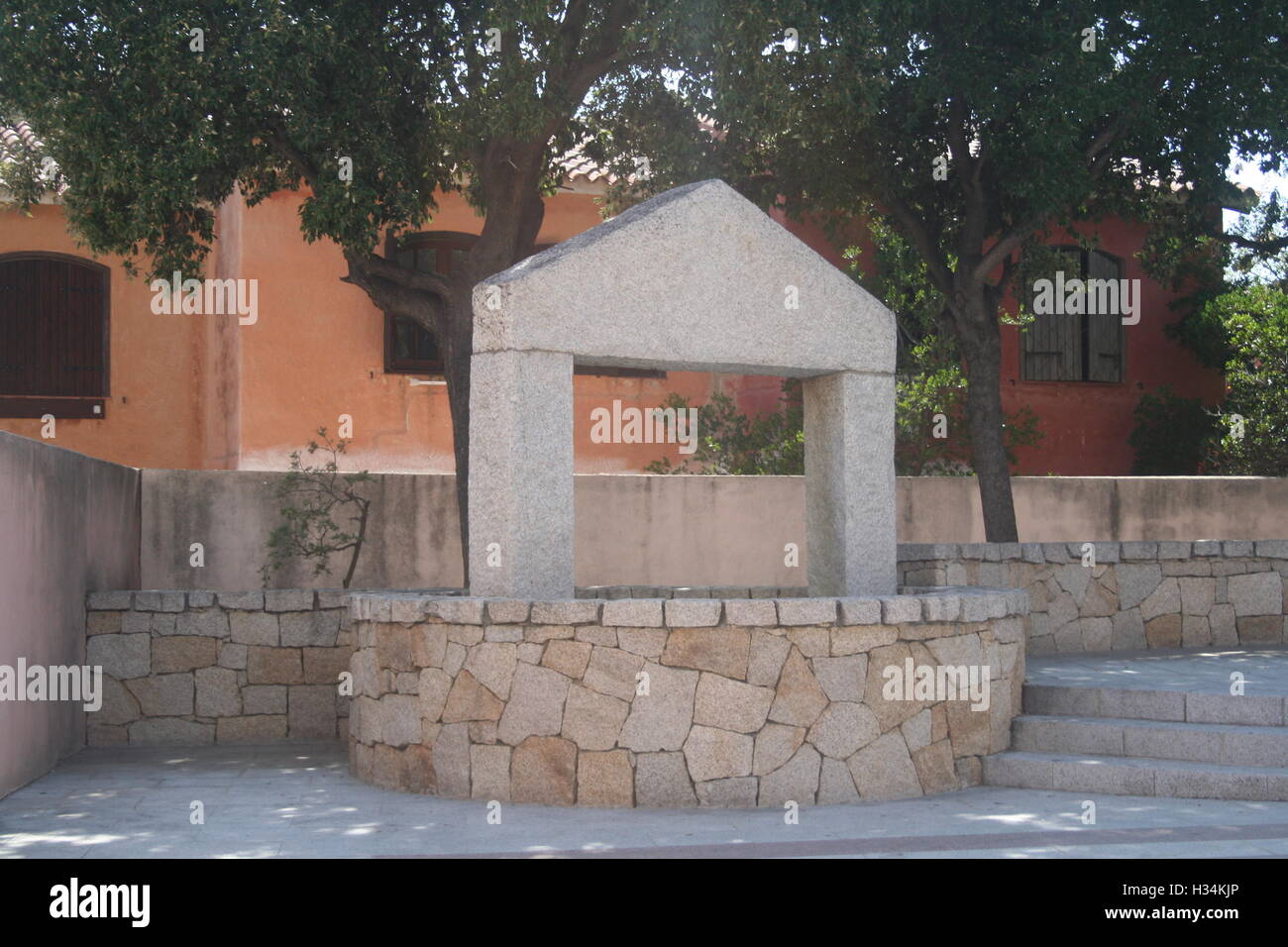 A stone well, beside some steps, in a town in Sardinia, Italy Stock ...