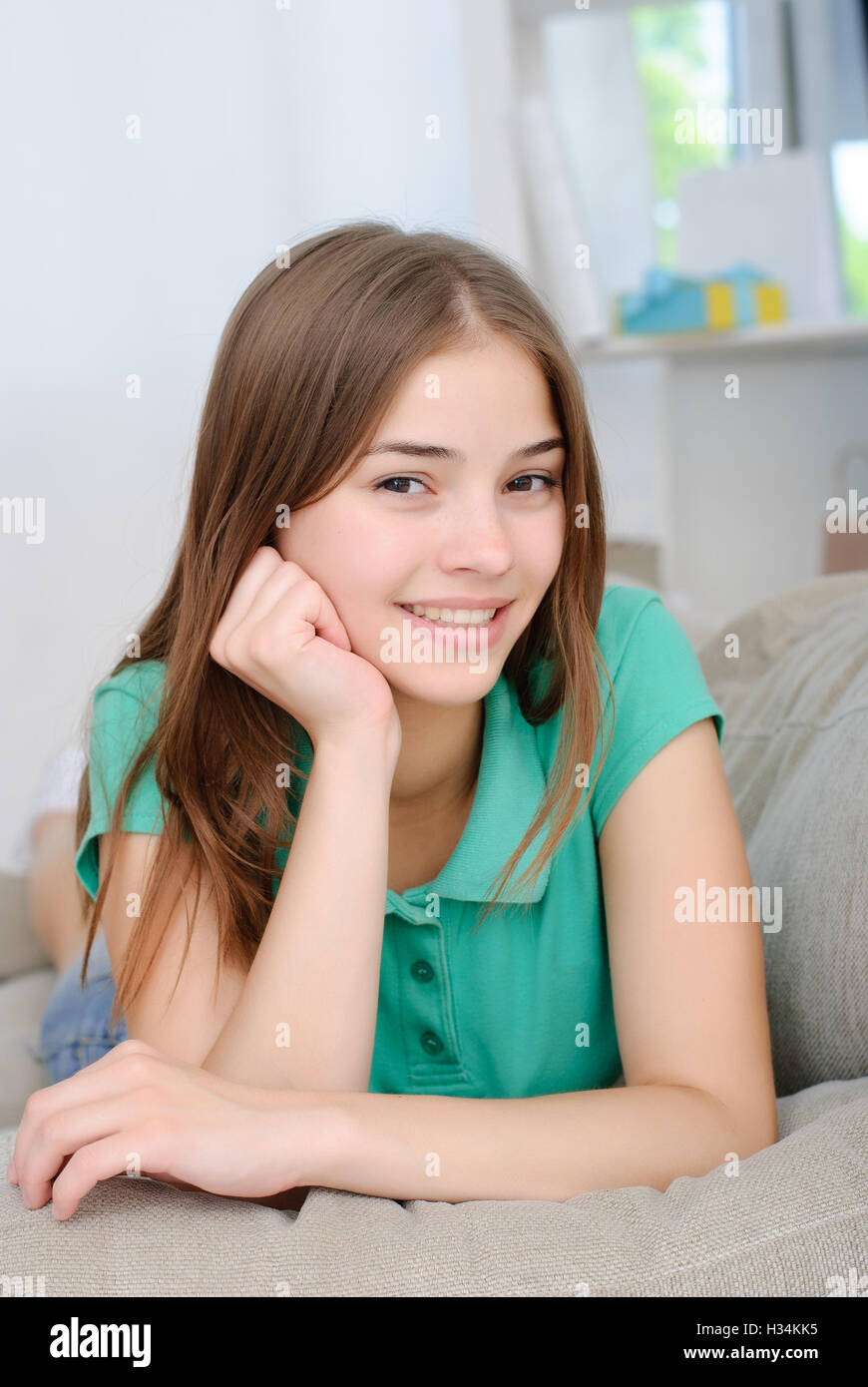 Portrait of young woman sitting on couch in her living room Stock Photo ...