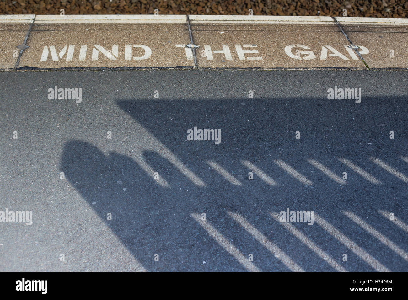 Mind the gap stencil on railway station platform Stock Photo - Alamy