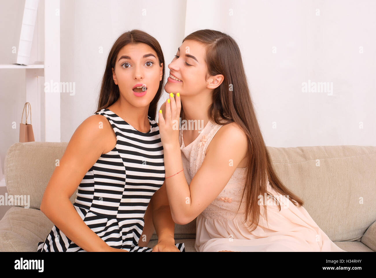 two girls gossip on gray background Stock Photo - Alamy