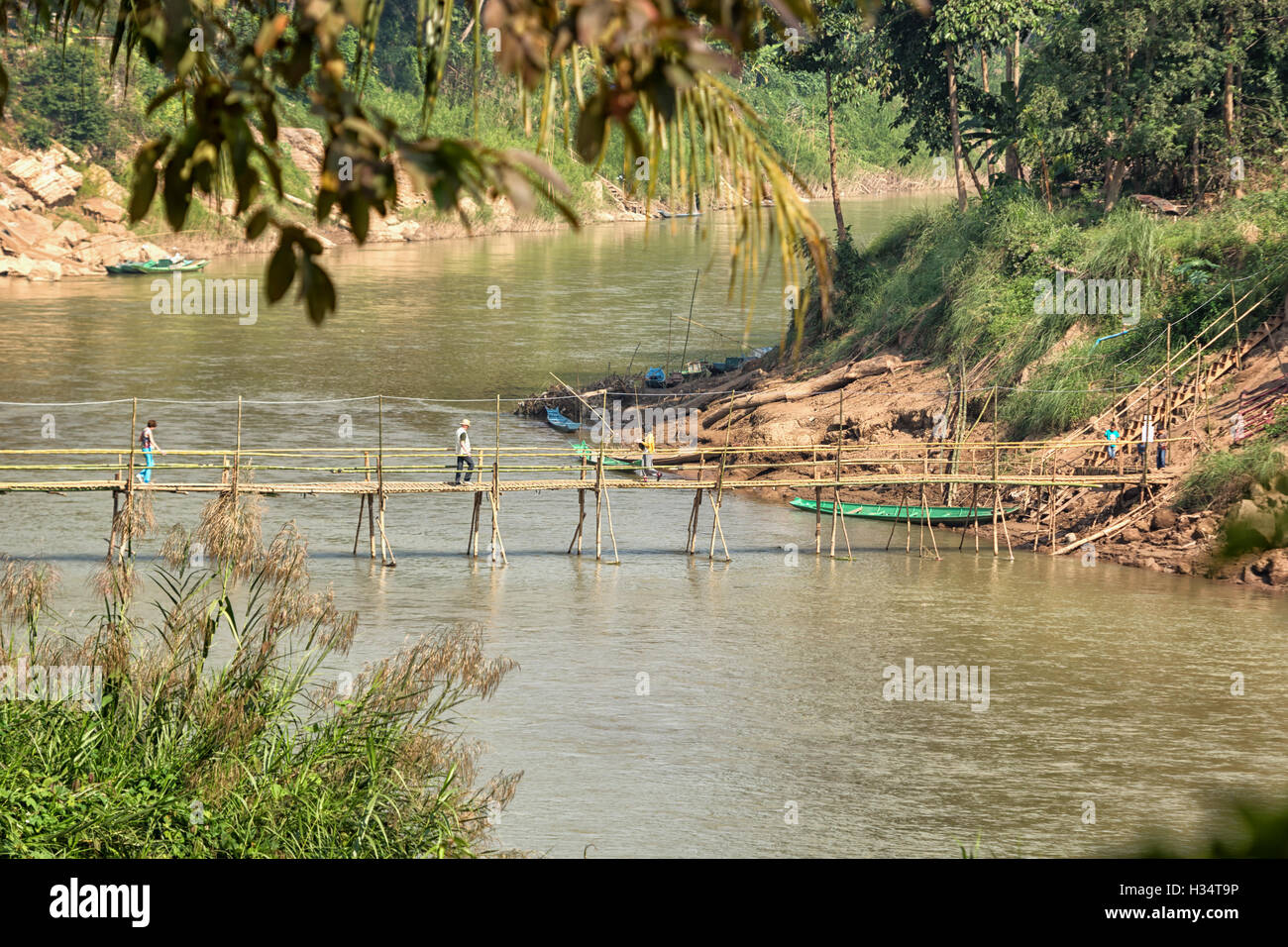 Luang Prabang, Laos - Bamboo bridge across the river with the tourists ...
