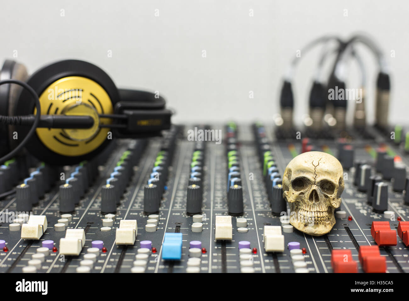 Human skull resting on a sound mixer. Background on the mixer console ...