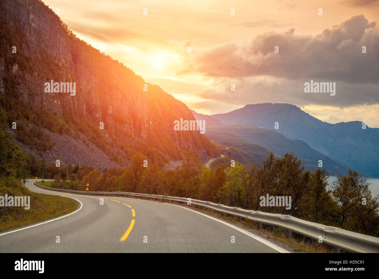 Mountain road at sunset Stock Photo - Alamy