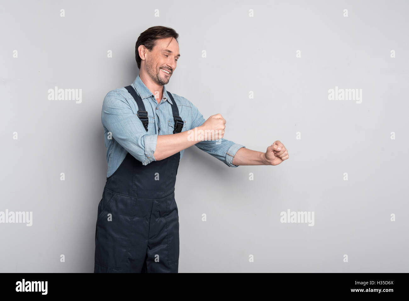 Diligent worker stand against grey background Stock Photo - Alamy