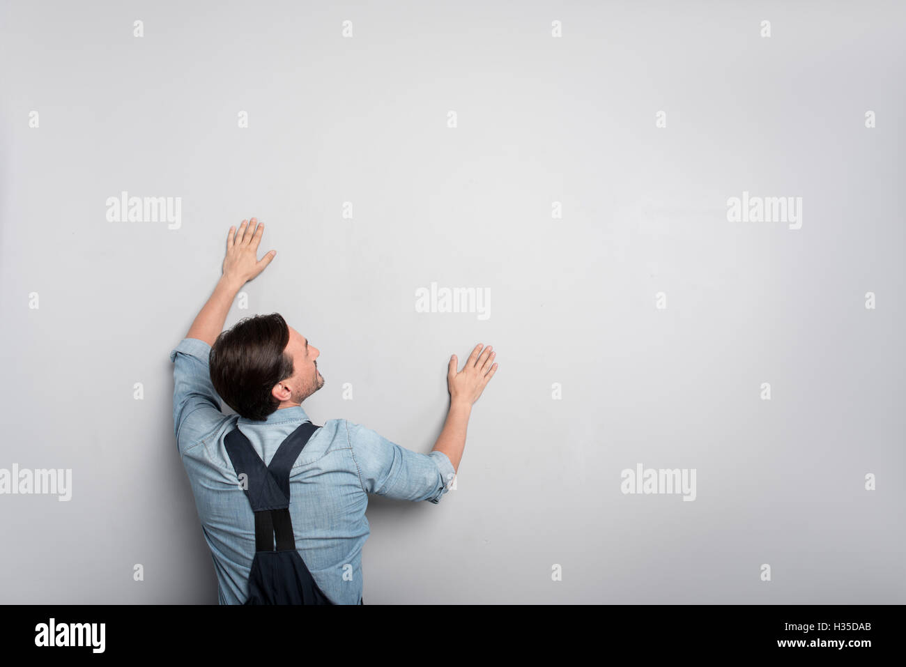 Joyful handsome man leaning on the wall Stock Photo - Alamy