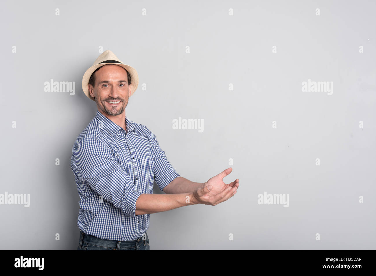 Emotional pleasant man pretending to hold something Stock Photo - Alamy