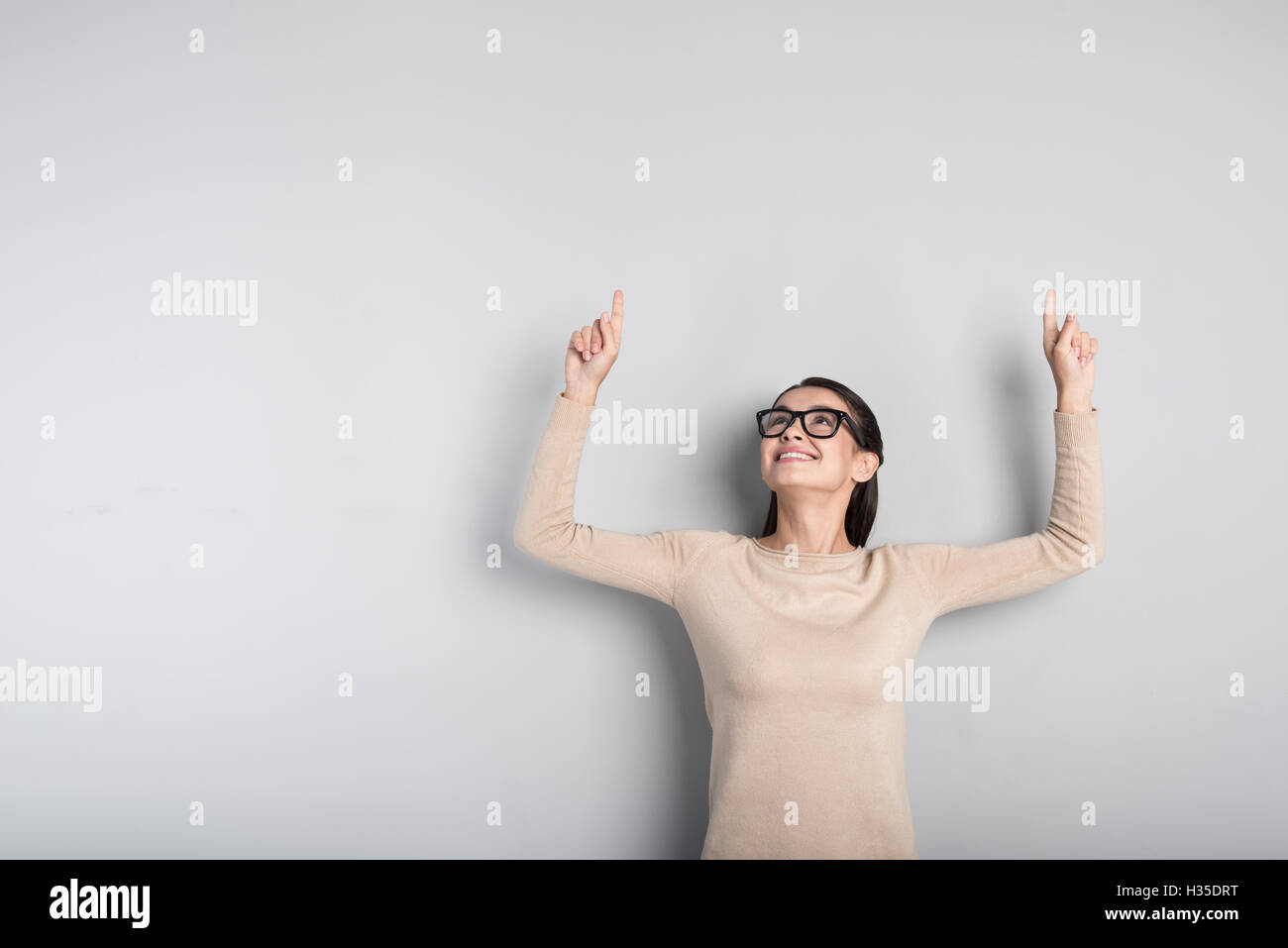 Positive delighted woman standing isolated on grey background Stock ...